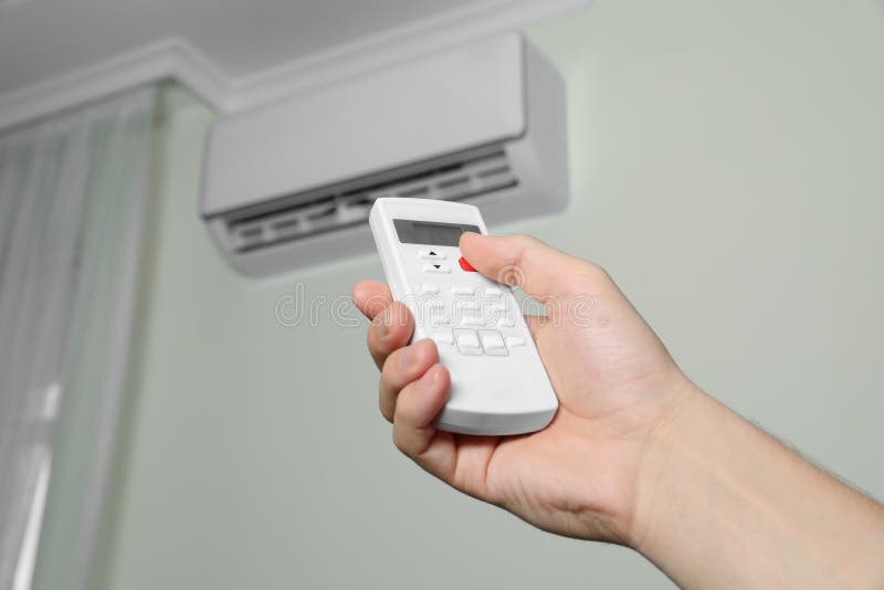 Man Operating Air Conditioner with Remote Control Indoors, Closeup ...