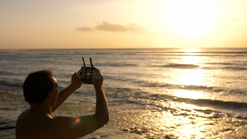 Man Operating a Drone with Remote Control. Quadro Copter Drone Flying ...