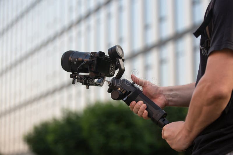 A Man Operating Camera Mounted on a Gimbal, Focus on the Gimbal and ...