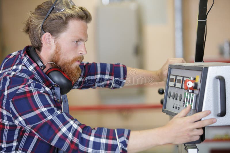 Man operating machine stock photo. Image of manufacturer - 197679246
