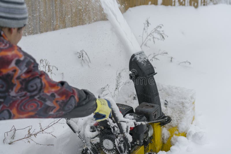 Man Operating Snow Blower To Remove Snow on Driveway. Man Using a ...