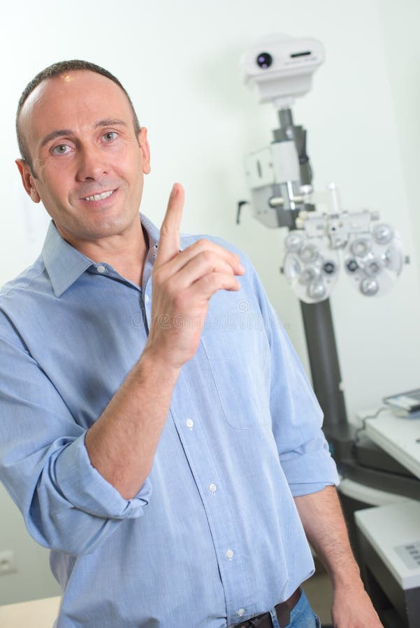 Man in opticians pointing stock photo. Image of vision - 196366182