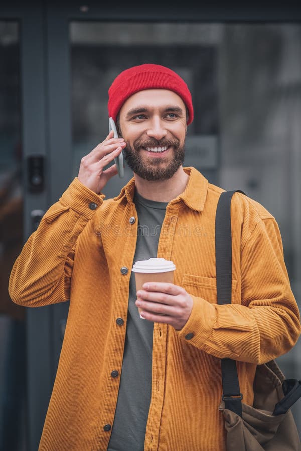 Man in an Orange Jacket with a Phone in His Hands Stock Photo - Image ...
