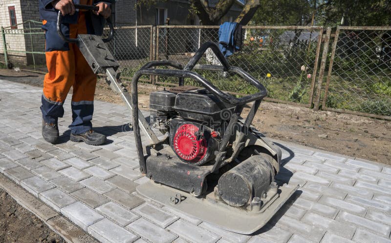 Man in Orange Uniform Using Vibrational Paving Stone Machine for Finish ...