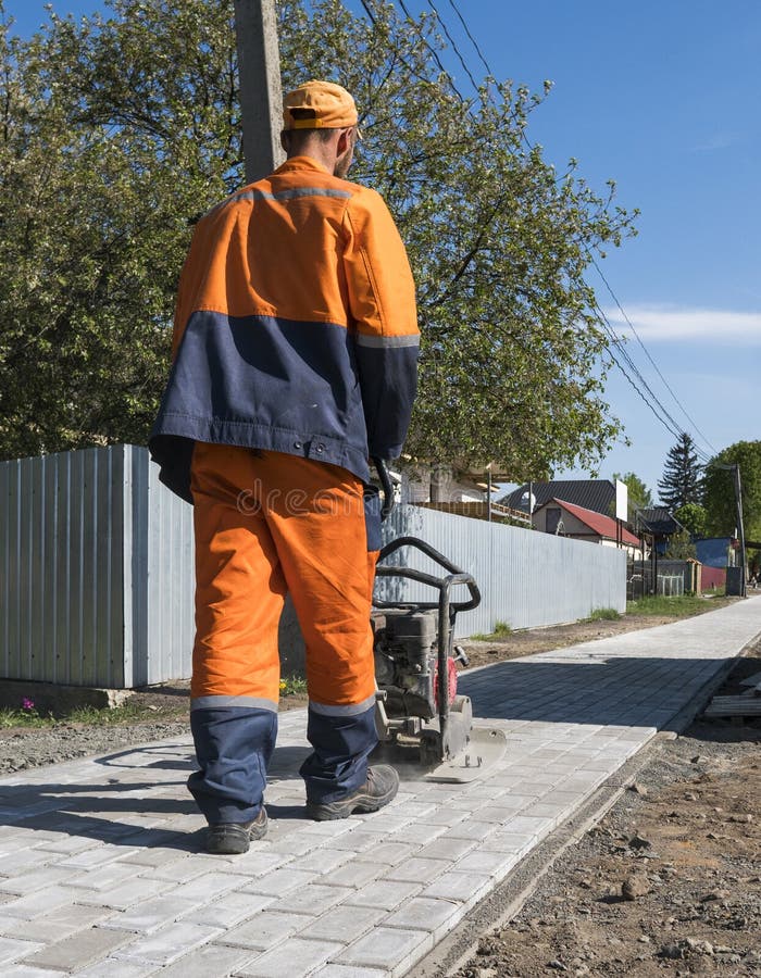 Man in Orange Uniform Using Vibrational Paving Stone Machine for Finish ...