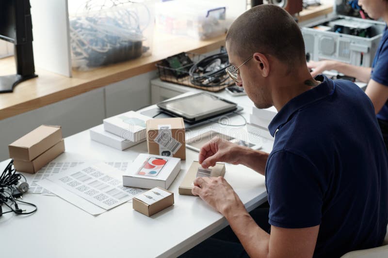 Man Organizing Boxes on Desk in Office Setting Stock Photo - Image of ...