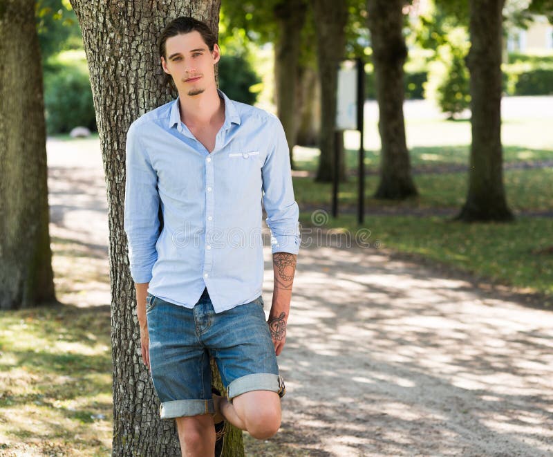 Man Outdoors Leaning on a Tree Stock Image - Image of positive, smiling ...