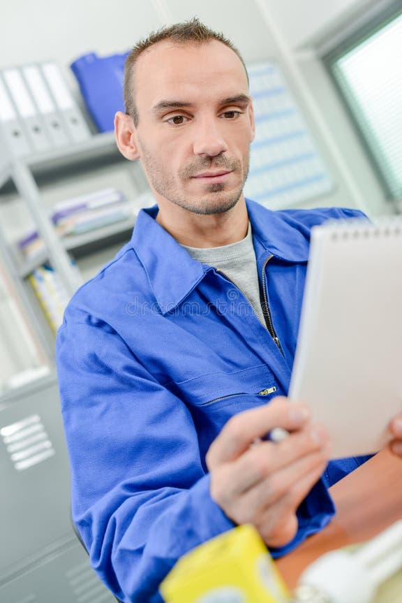 Man in Overalls Looking at Notepad Stock Image - Image of office ...
