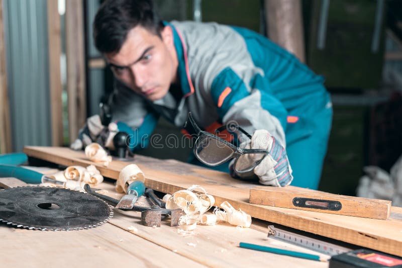 Man in Overalls Planing a Tree in the Studio with a Hand Planer Stock ...