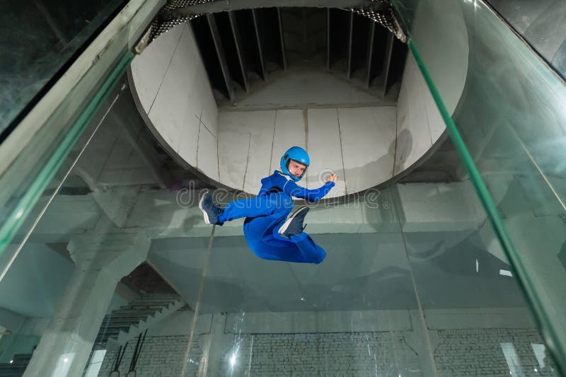 A Man in Overalls and a Protective Helmet Enjoys Flying in a Wind ...