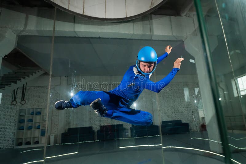 A Man in Overalls and a Protective Helmet Enjoys Flying in a Wind ...