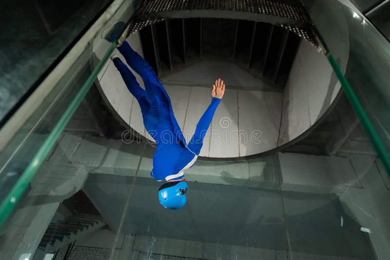 A Man in Overalls and a Protective Helmet Enjoys Flying in a Wind ...