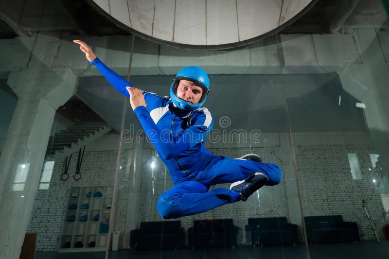 A Man in Overalls and a Protective Helmet Enjoys Flying in a Wind ...