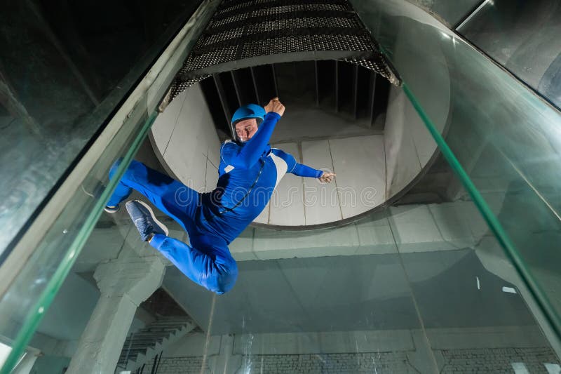 A Man in Overalls and a Protective Helmet Enjoys Flying in a Wind ...
