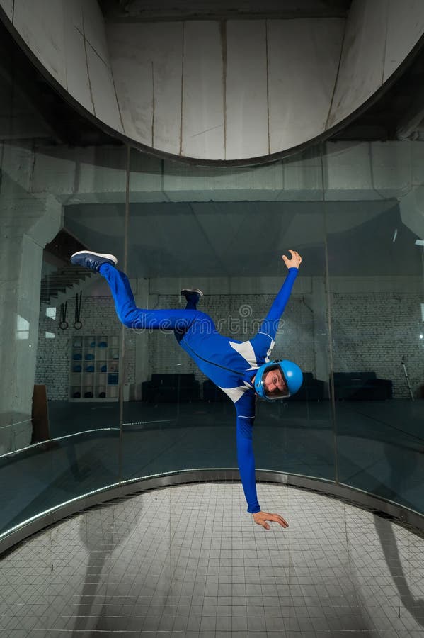 A Man in Overalls and a Protective Helmet Enjoys Flying in a Wind ...
