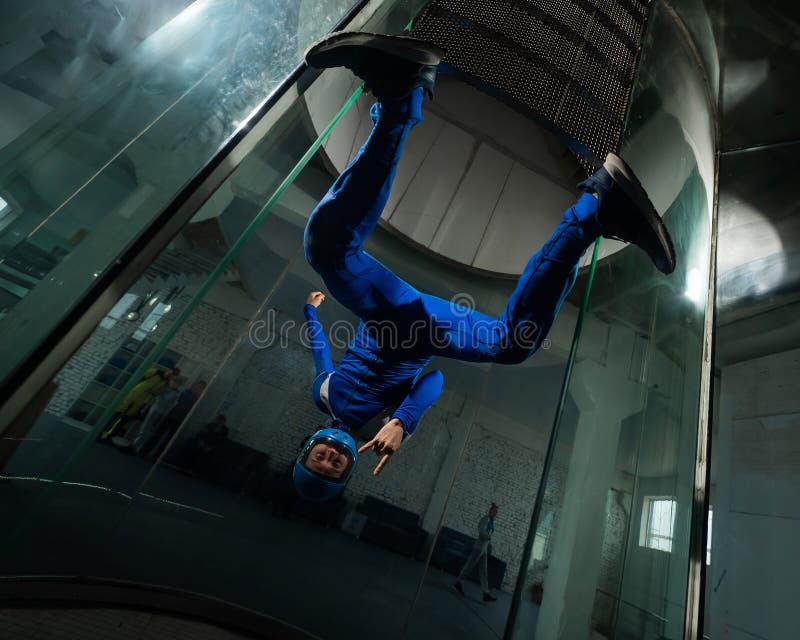 A Man in Overalls and a Protective Helmet Enjoys Flying in a Wind ...