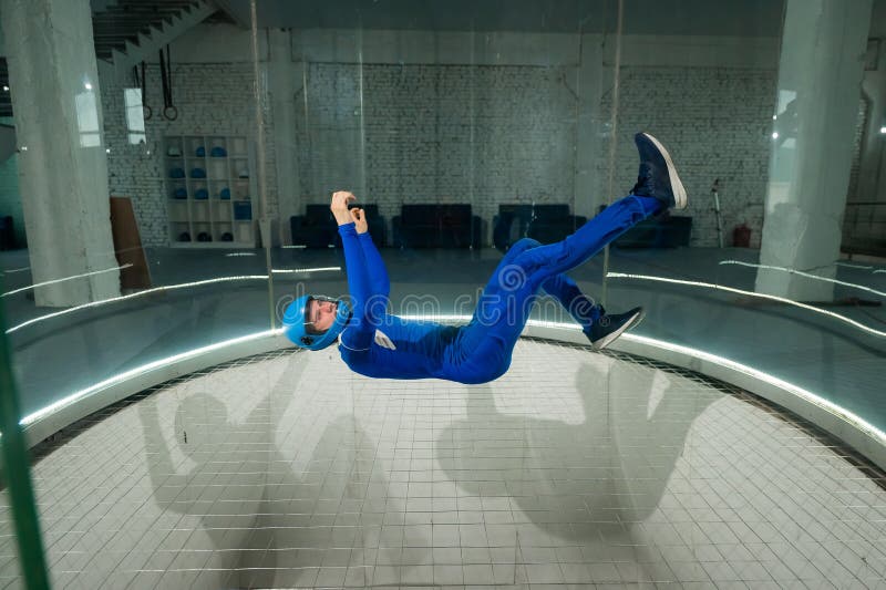 A Man in Overalls and a Protective Helmet Enjoys Flying in a Wind ...