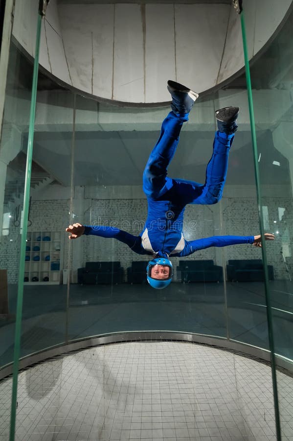 A Man in Overalls and a Protective Helmet Enjoys Flying in a Wind ...
