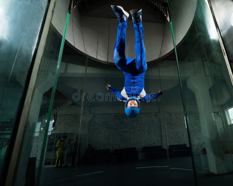 A Man in Overalls and a Protective Helmet Enjoys Flying in a Wind ...