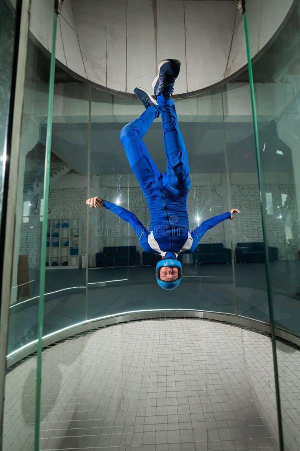 A Man in Overalls and a Protective Helmet Enjoys Flying in a Wind ...