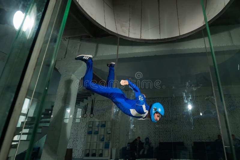 A Man in Overalls and a Protective Helmet Enjoys Flying in a Wind ...
