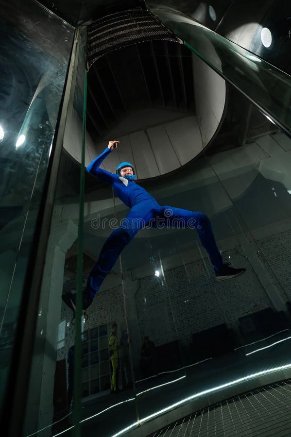 A Man in Overalls and a Protective Helmet Enjoys Flying in a Wind ...