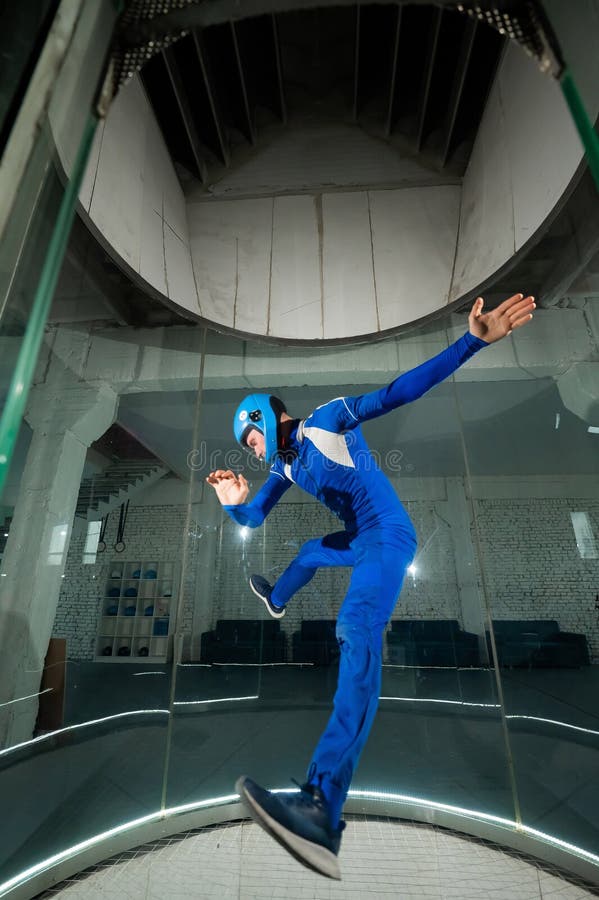 A Man in Overalls and a Protective Helmet Enjoys Flying in a Wind ...