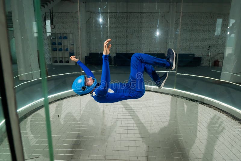 A Man in Overalls and a Protective Helmet Enjoys Flying in a Wind ...