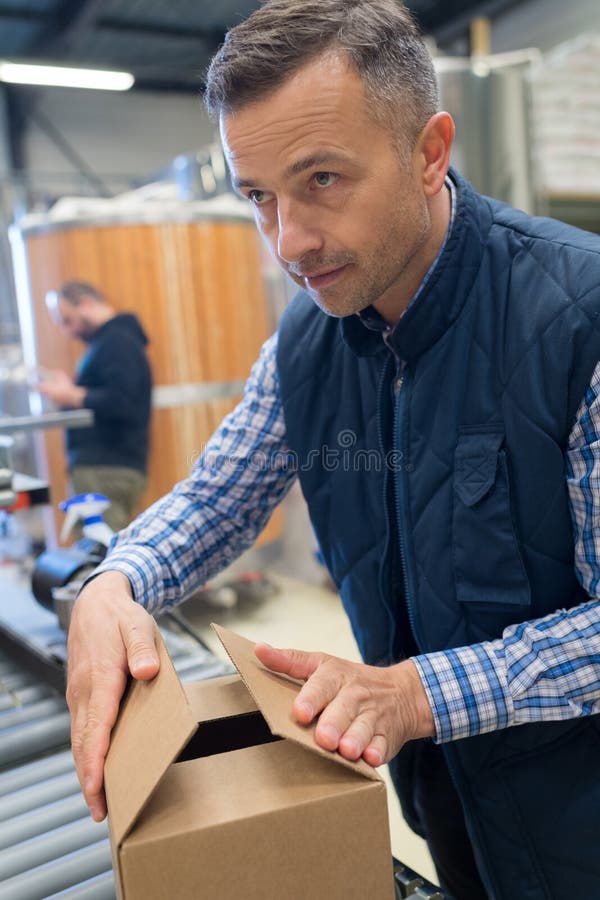 Man Packaging Product on End Production Line Stock Photo - Image of ...