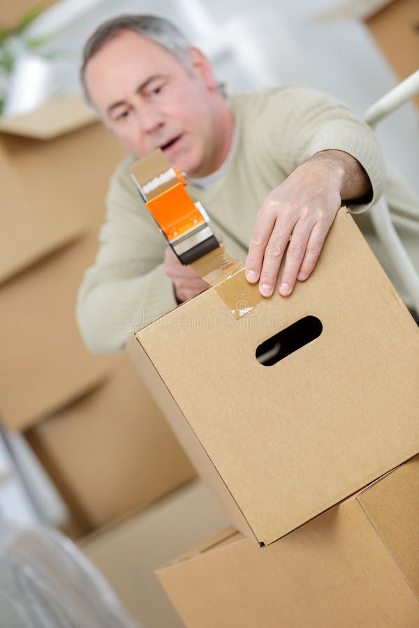 Man packing boxes close-up stock photo. Image of scotch - 304133346
