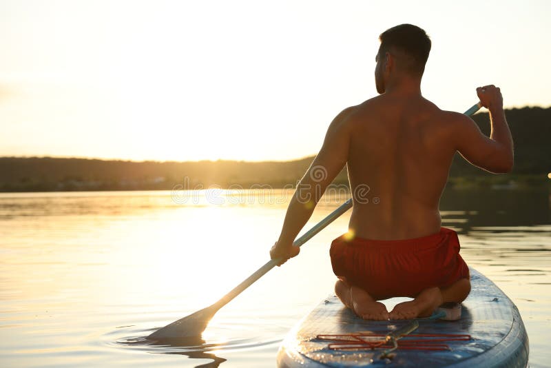 Man Paddle Boarding on SUP Board in River at Sunset, Back View Stock ...