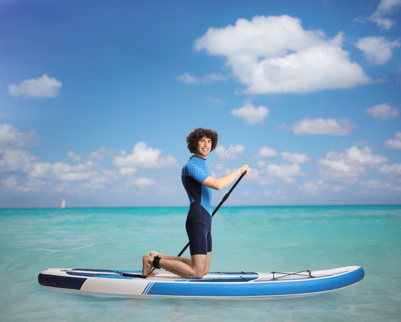 Man with a Paddle Kneeling on a Sup Board Stock Photo - Image of ...