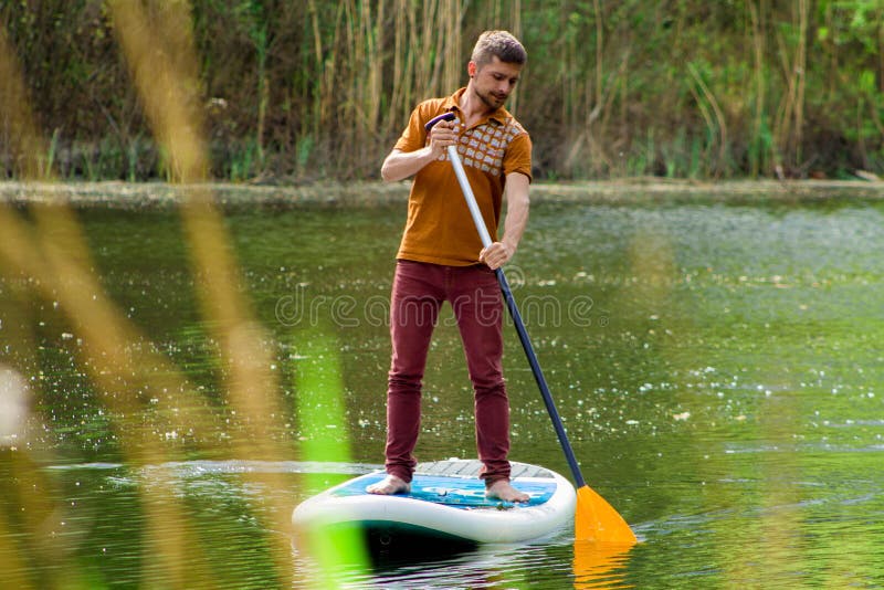 A Man with a Paddle on a Sup Board Stock Photo - Image of board ...