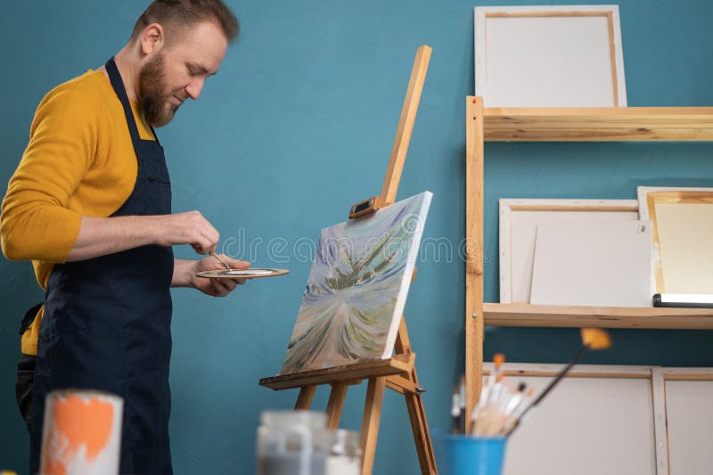 Man Painter Standing in Front of the Canvas and Drawing. Artist Using ...