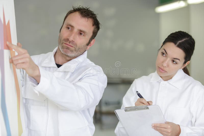 Man Painting Wall while Apprentice Taking Notes Stock Image - Image of ...