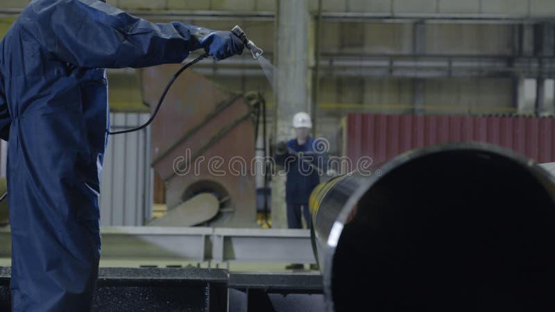 Man Paints Pipe Atomizer. Mens Hand Paint the Pipes on the Plant ...