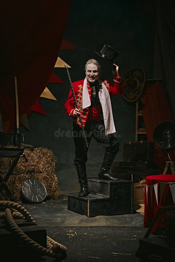 Man with Pale Face Makeup, in Red Stage Costume and Hat Making Creative ...