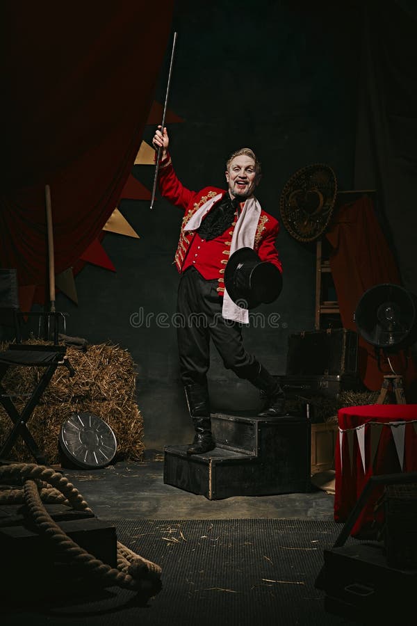 Man with Pale Face Makeup, in Red Stage Costume and Hat Making Creative ...