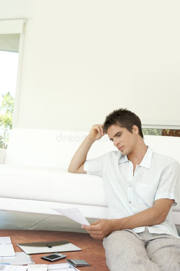 Man with Paperwork Sitting on Floor Stock Image - Image of glass, couch ...