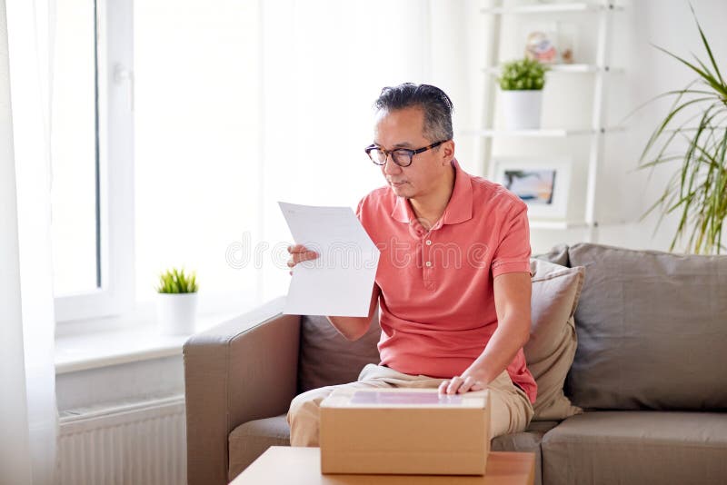 Man with Parcel Box Reading Invoice at Home Stock Image - Image of ...