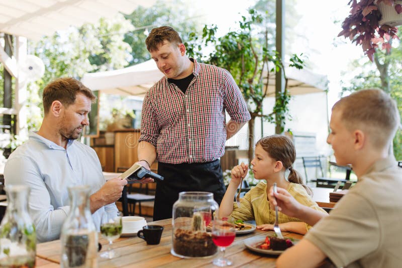 Man Paying for Lunch in Restaurant, Paying by Card. Holding Card Near ...