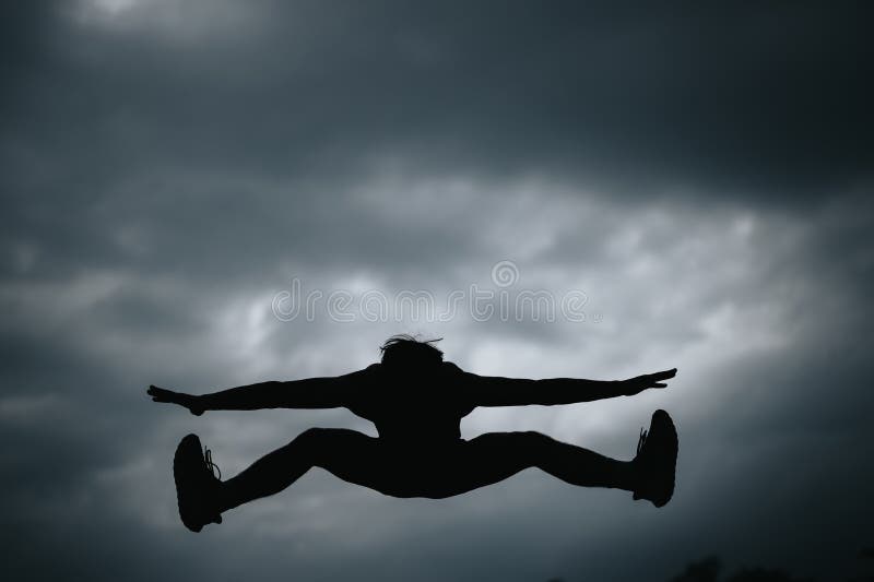 Silhouette of Man Performing High Jump Against Cloudy Sky Stock Photo ...