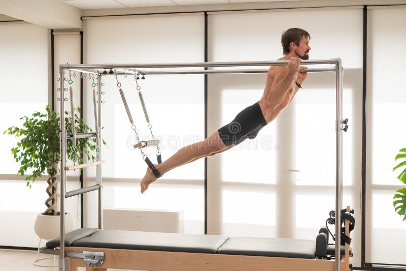 A Man Performs Aerial Exercises on a Reformer Machine. Stock Image ...