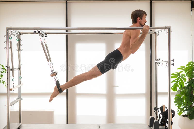 A Man Performs Aerial Exercises on a Reformer Machine. Stock Photo ...