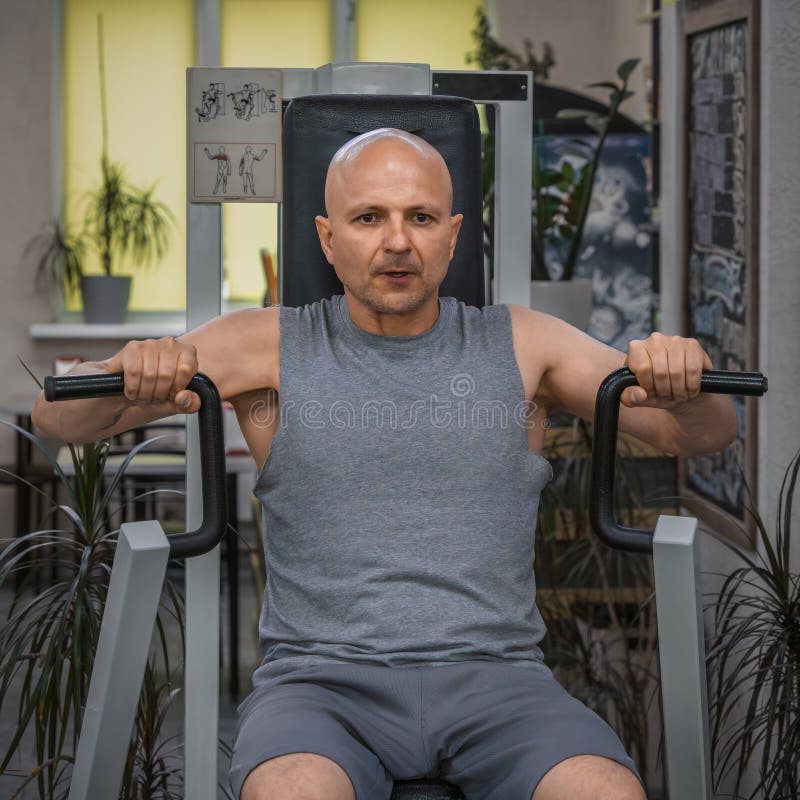 Man Performs an Exercise on a Simulator for Pumping Chest Muscles Stock ...