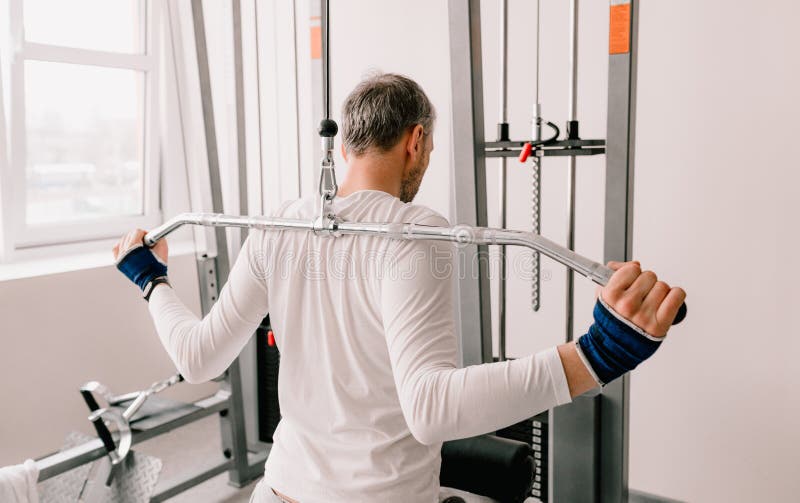 A Man Performs Exercises in the Gym on a Simulator. Back Training Stock ...