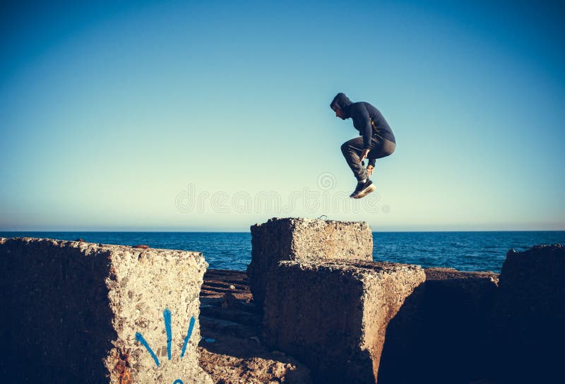 Man Performs Freerunning Jump on Stones Stock Photo - Image of sport ...