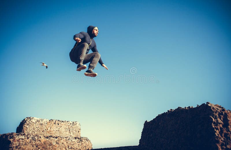 Man Performs Freerunning Jump on Stones Stock Image - Image of fall ...