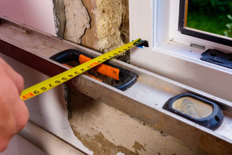 The Man Performs Installation Work with the Window, for this he Also ...