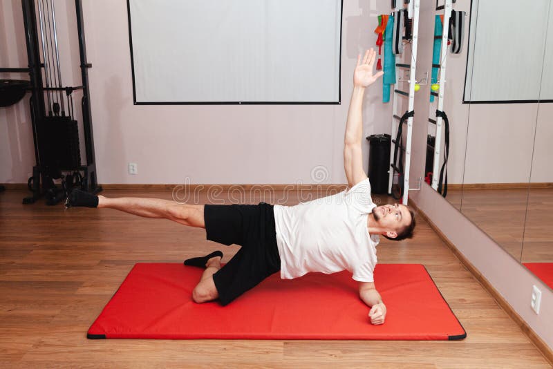 A Man Performs the Plank Exercise on a Red Mat in the Gym Stock Image ...
